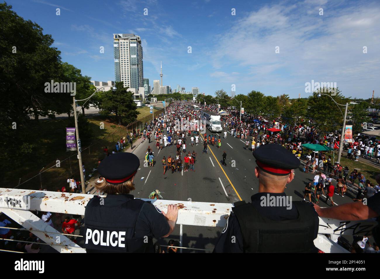 Police look on as bands and pedestrians revel in the music as they walk ...