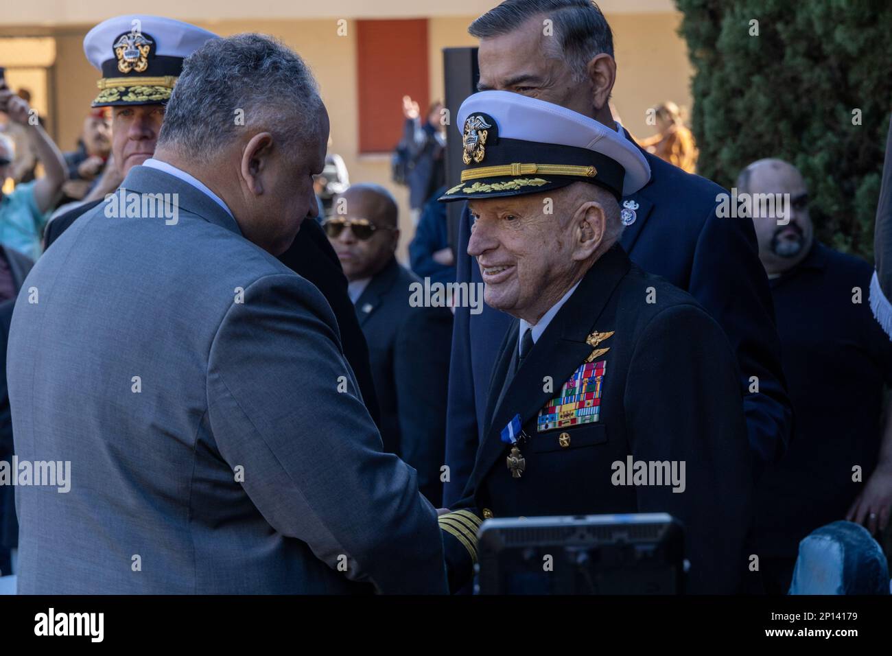 Secretary of the Navy Carlos Del Toro (left), congratulates retired U.S ...