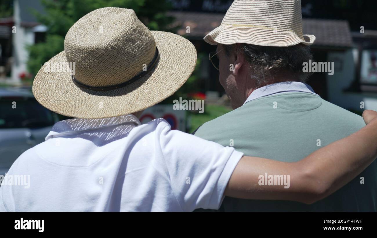 Back of teenager kid hugging senior grandparent with arm around. Two ...