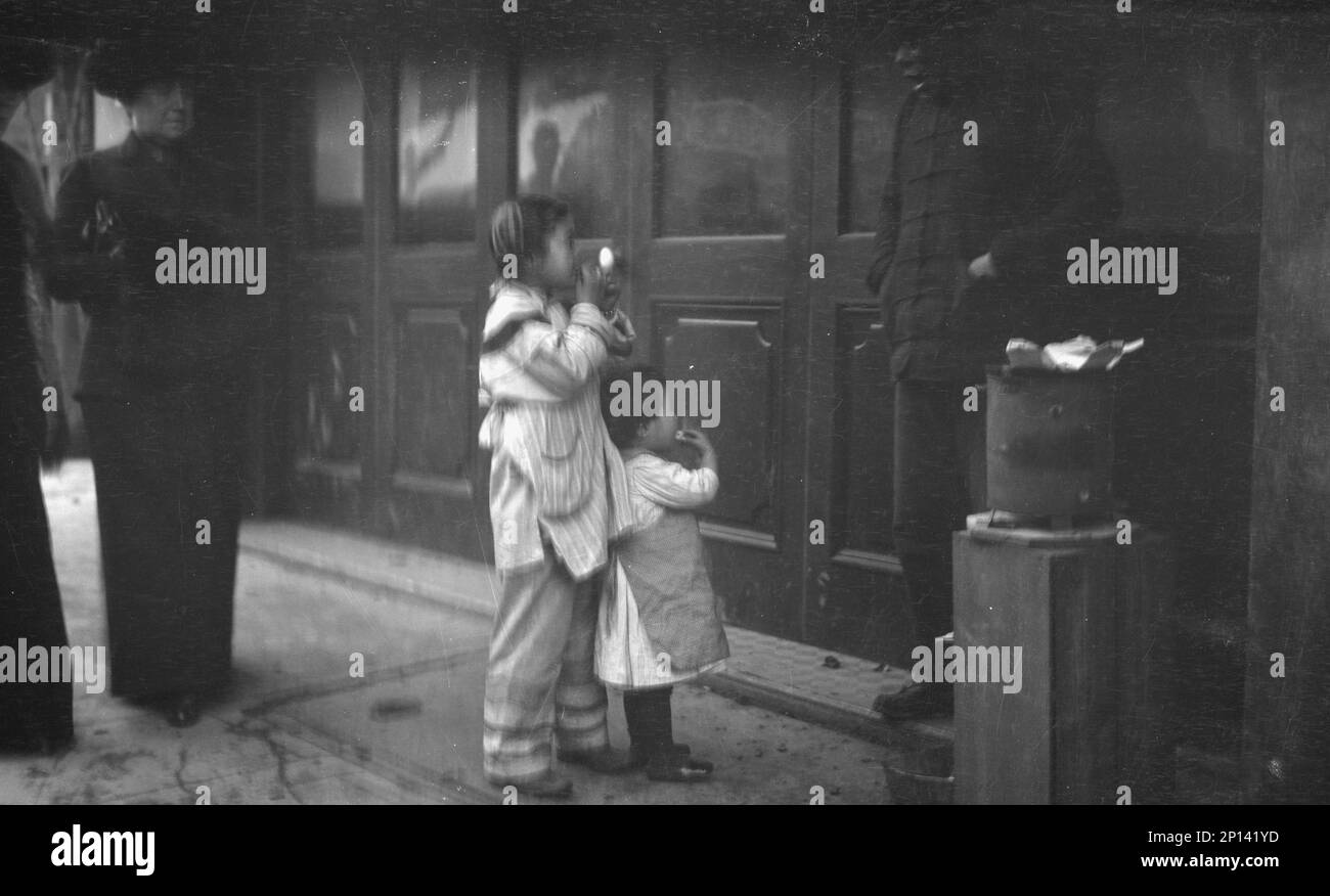 Two children standing on a sidewalk eating, Chinatown, San Francisco ...