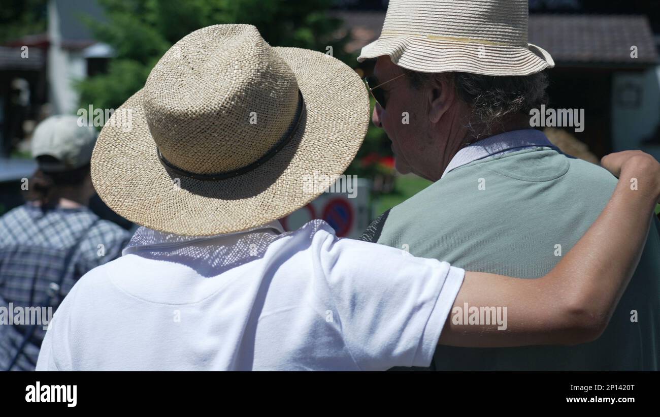 Back of teenager kid hugging senior grandparent with arm around. Two ...