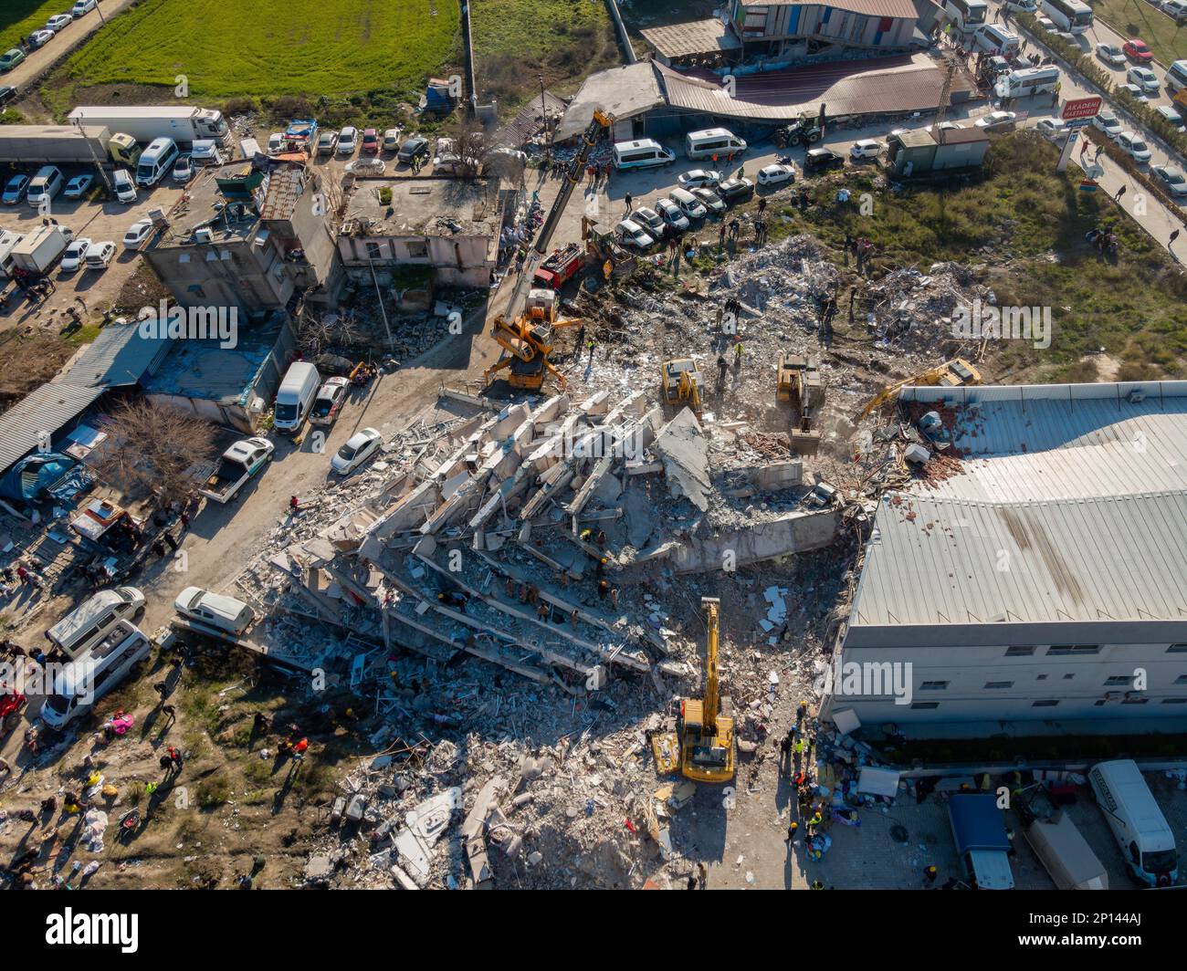 A destroyed building with an exposed roof, debris scattered across the ...