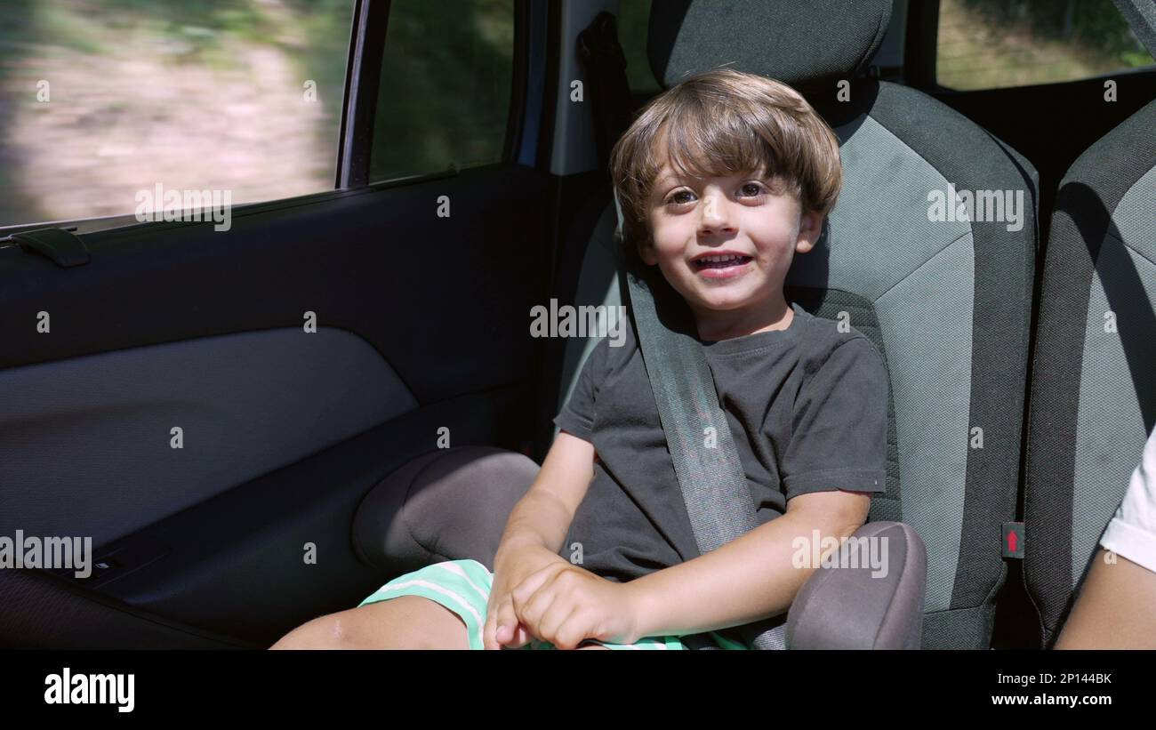 One happy small boy seated in car backseat smiling at camera. Child ...
