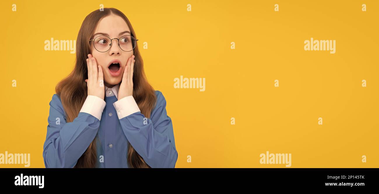 Shocked girl child in eyeglasses school education yellow background ...