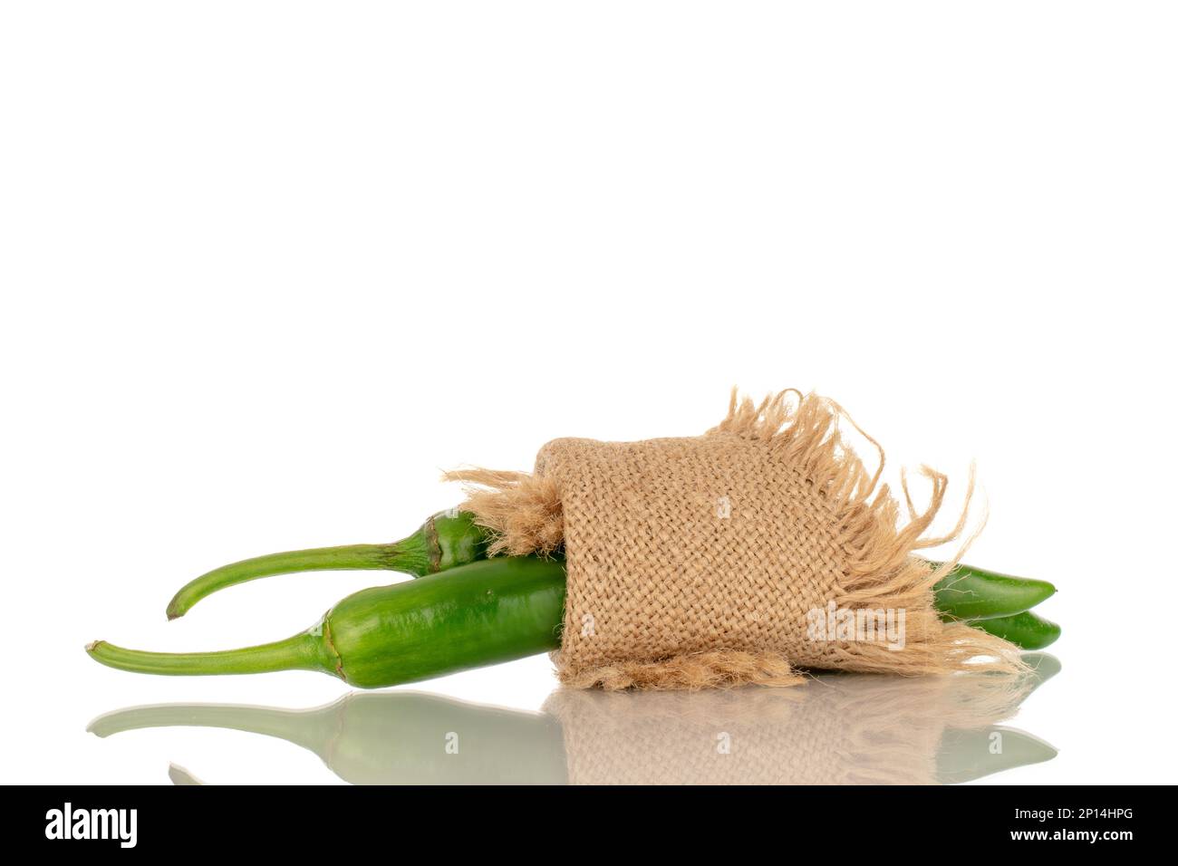 Two green spicy pepper with a jute cloth, a macro, isolated on a white ...