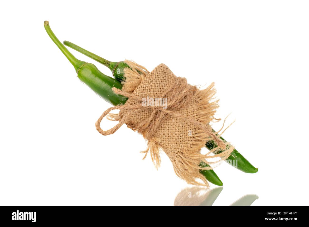 Two green spicy pepper with a jute cloth, a macro, isolated on a white ...