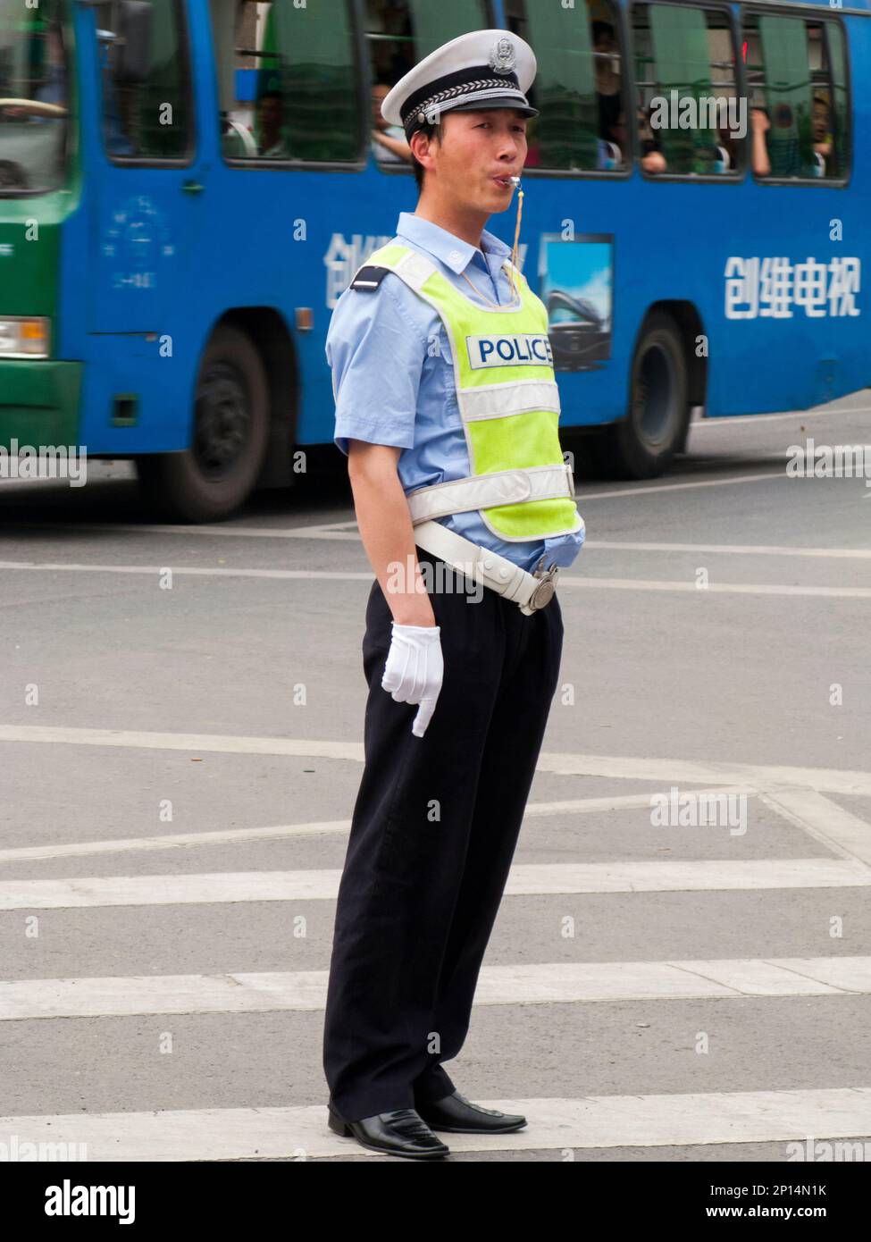 Police traffic officer policeman at a busy road junction in the Chinese ...