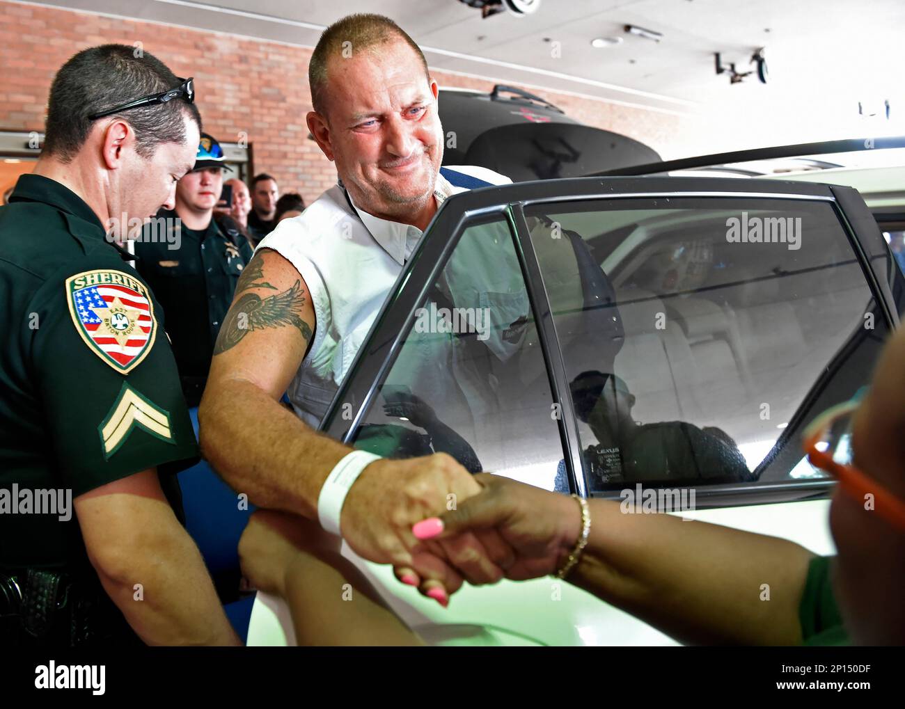 East Baton Rouge Parish Sheriff's Sgt. Bruce Simmons shakes hands with ...