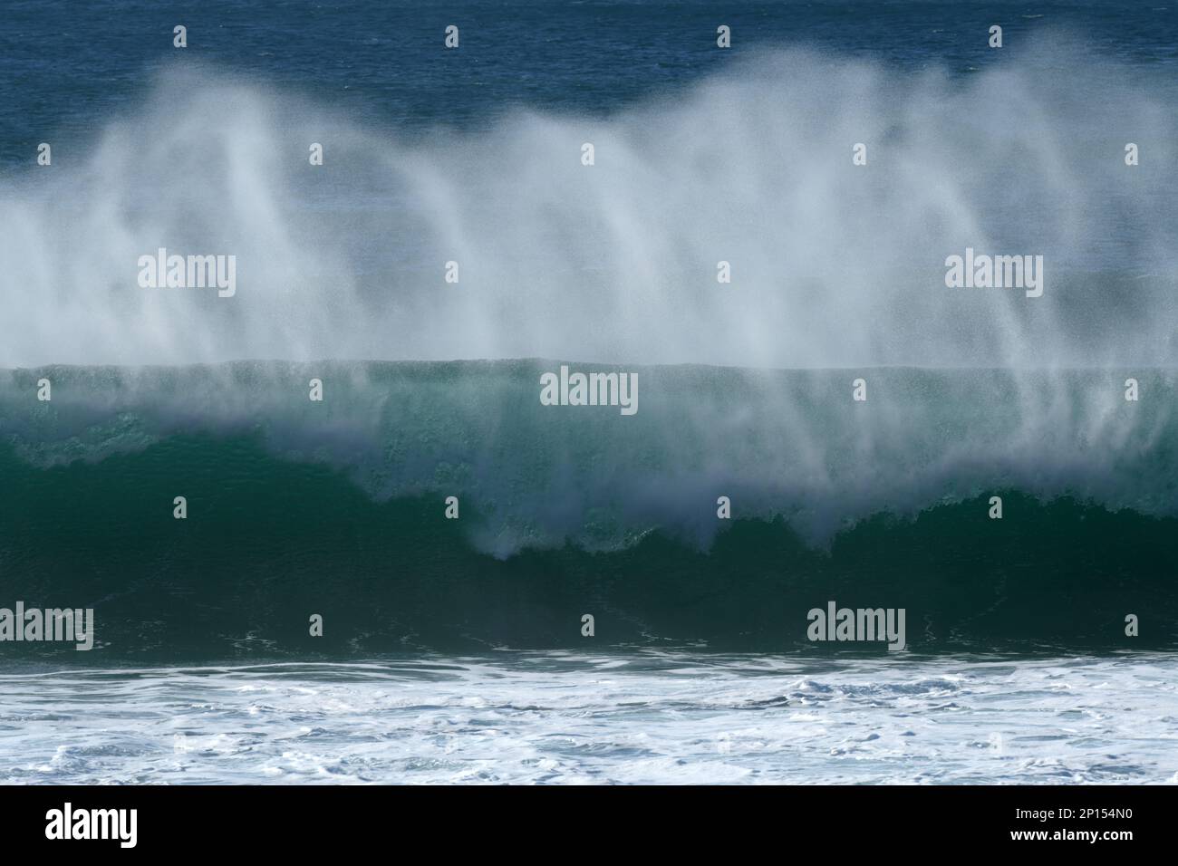 Close out. A wave crest cruches to the shore where beach and sea ...