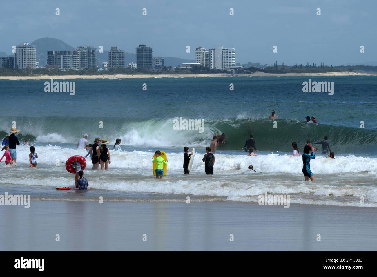 The Beach at Mooloolaba. Swimmers and bodysurfer in the surf, the sand ...