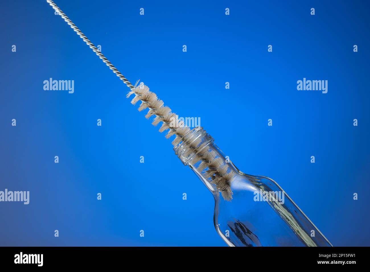 Thin wire brush for cleaning bottles. Inside small empty glass bottle ...