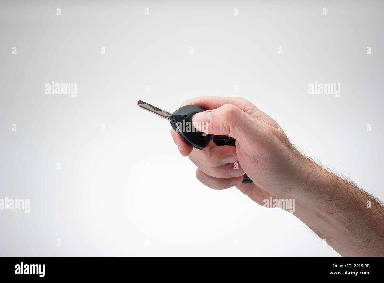 Generic plastic black car key fob held by Caucasian male hand. Close up ...