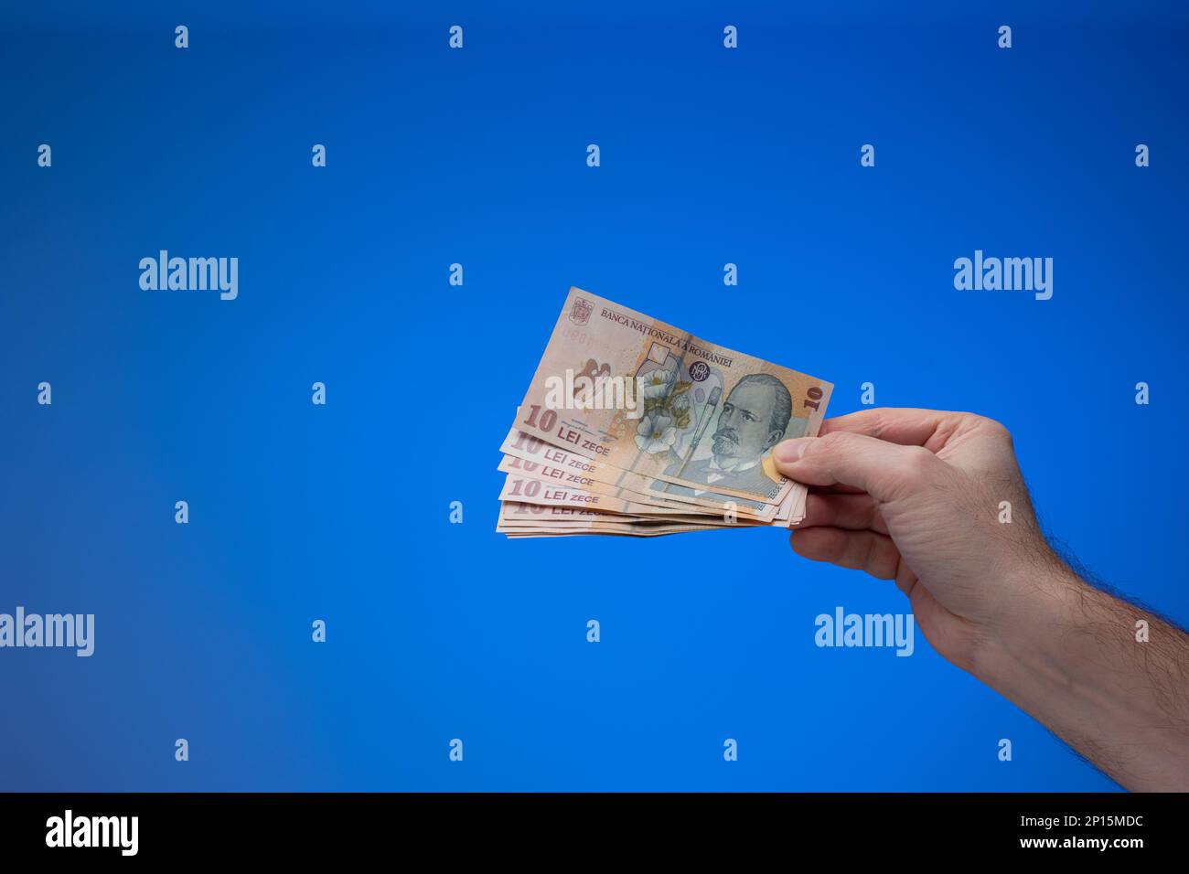 Romanian Lei currency banknotes held by male hand. Close up studio shot ...