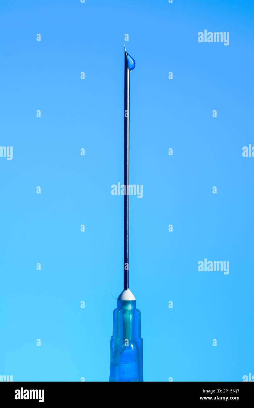 Syringe needle with liquid drop on the tip macro close up isolated on ...