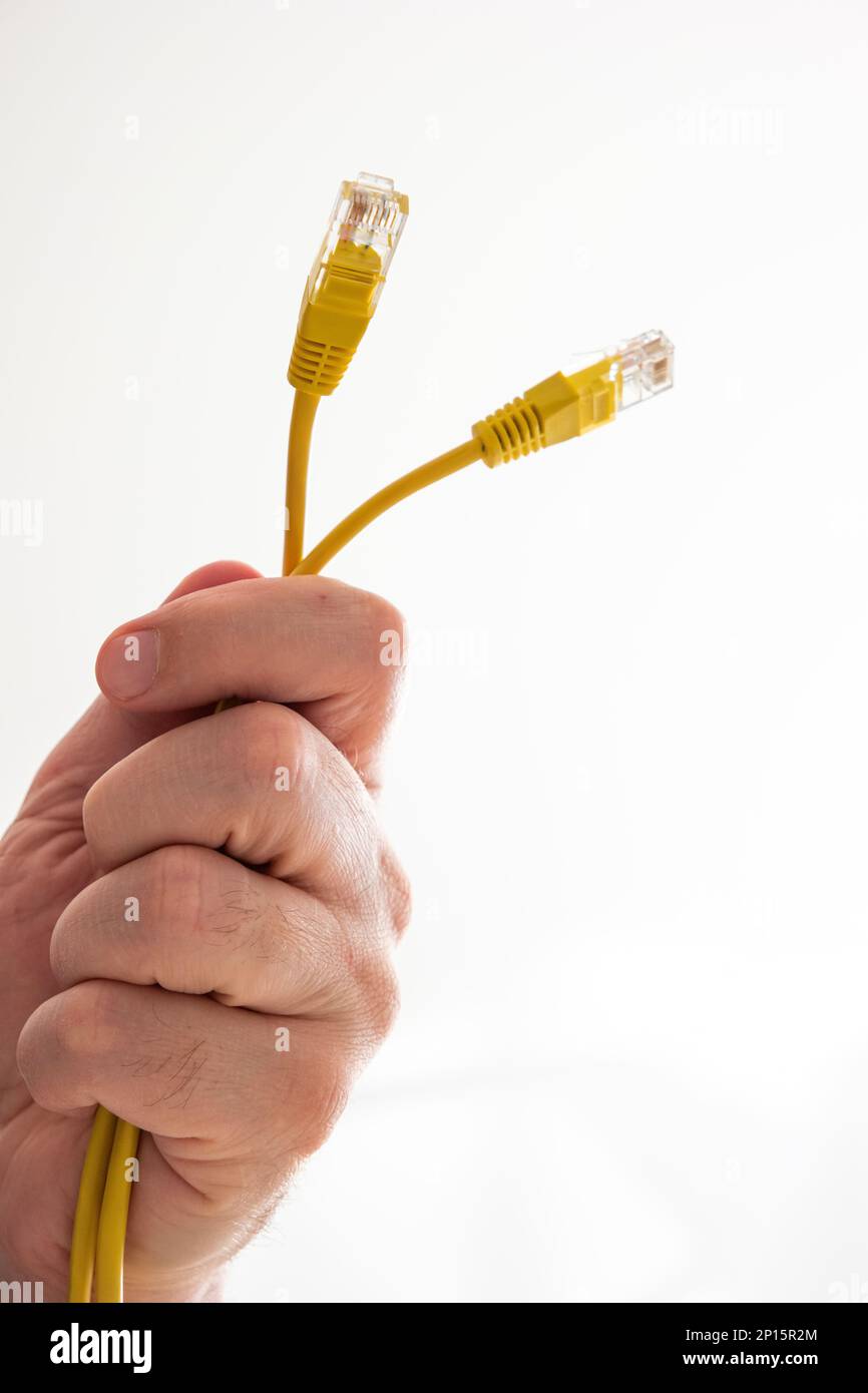 Caucasian male hand holding yellow Ethernet cable connectors close up ...