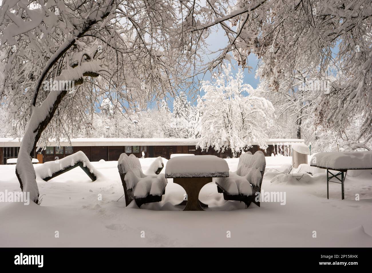 Snowy playground in the forest with snow covered picnic table and ...