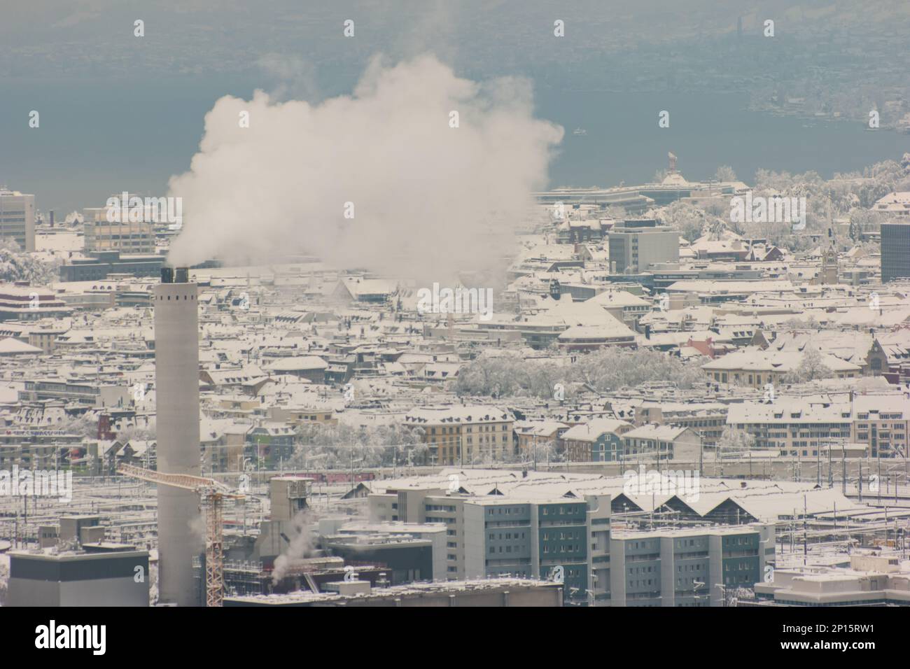 Aerial view of smoking chimney in snow covered Zurich city Switzerland ...