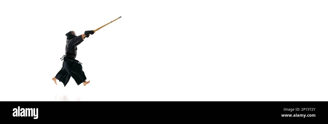 Man, professional kendo athlete in uniform training with bamboo sword ...