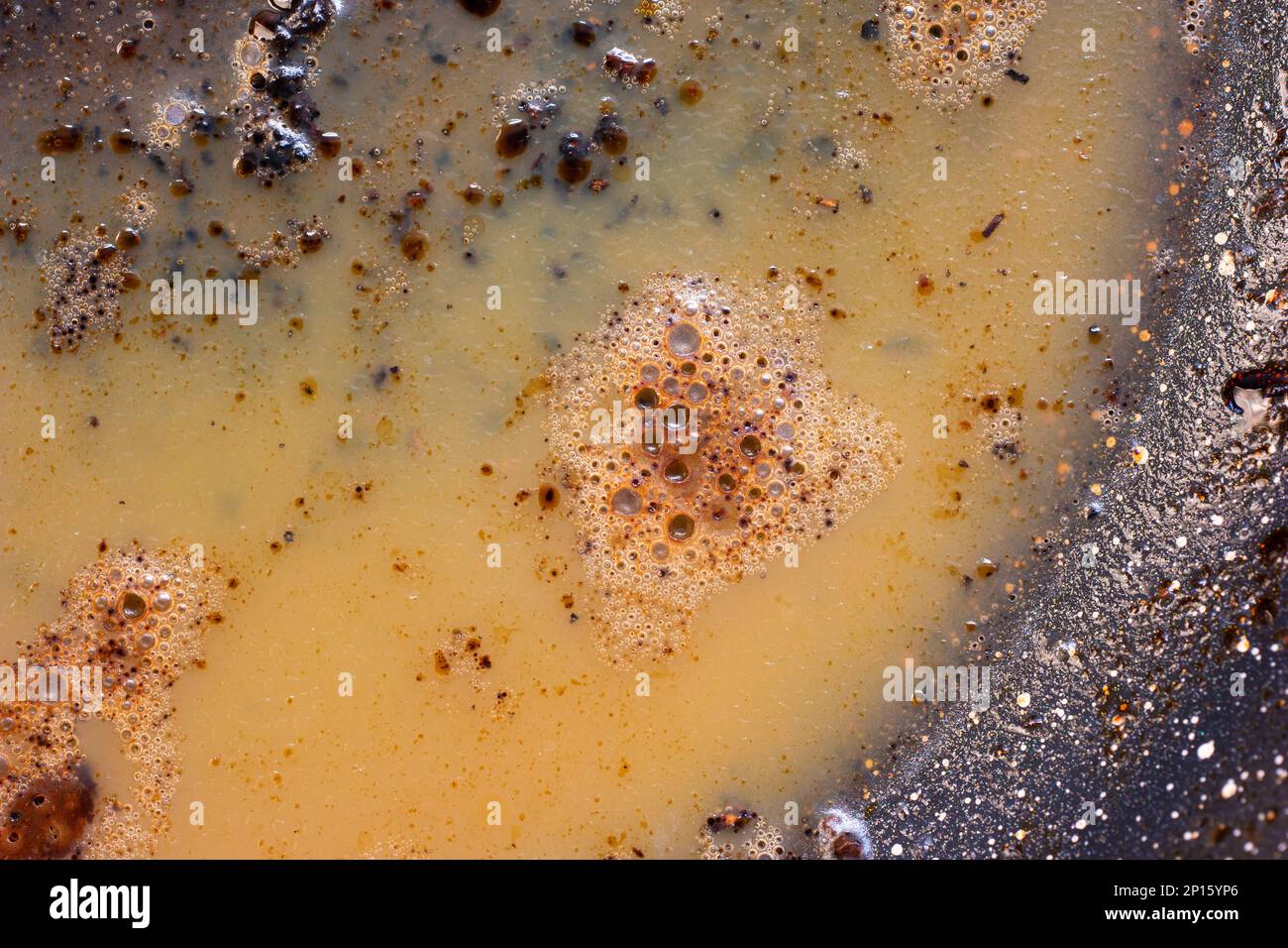 Burned oily leftover grease fat in a pan macro shot air bubbles top ...