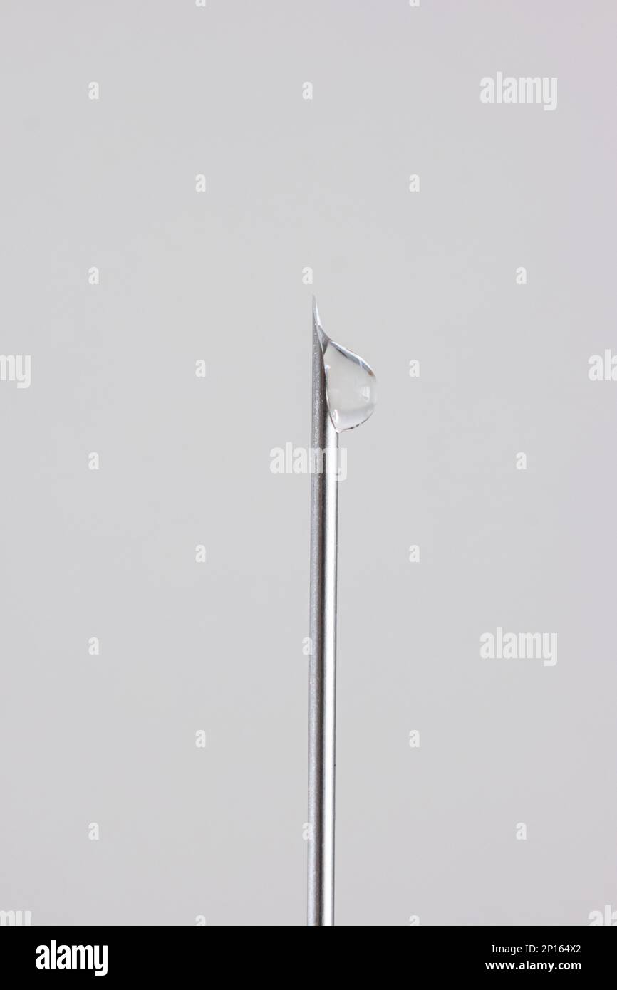 Syringe needle with liquid drop on the tip macro close up isolated on ...