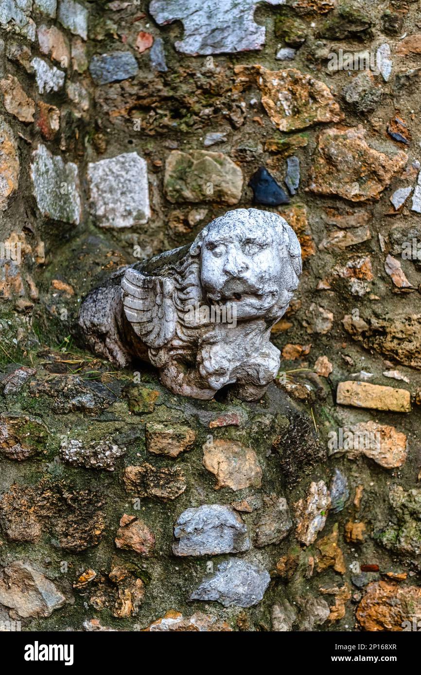 A stone sculpture with a male likeness in the stone wall of the ...