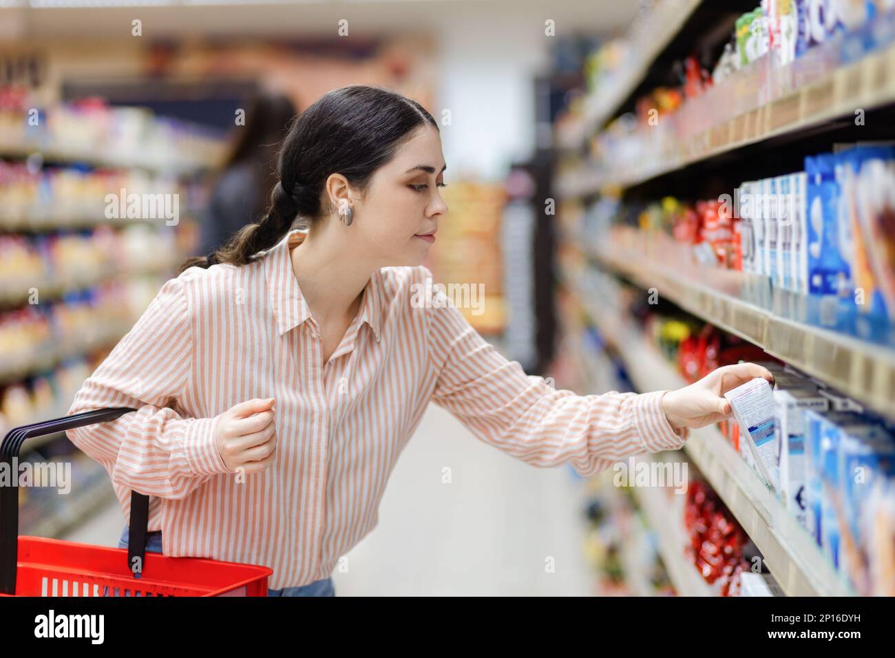 Visit grocery store. Young pretty caucasian woman takes food from ...