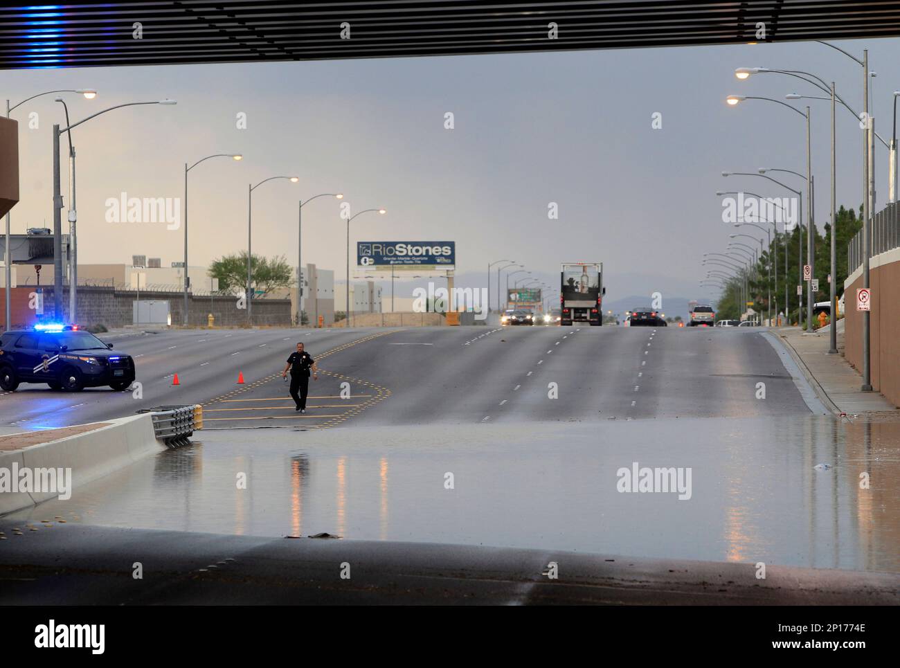 A Nevada Highway Patrol trooper stands by storm run-off at the railroad ...