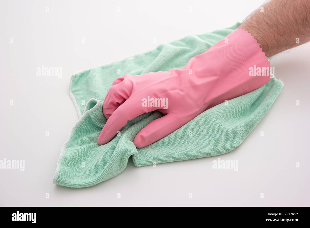 Pink latex cleaning glove on Caucasian male hand holding a light green ...