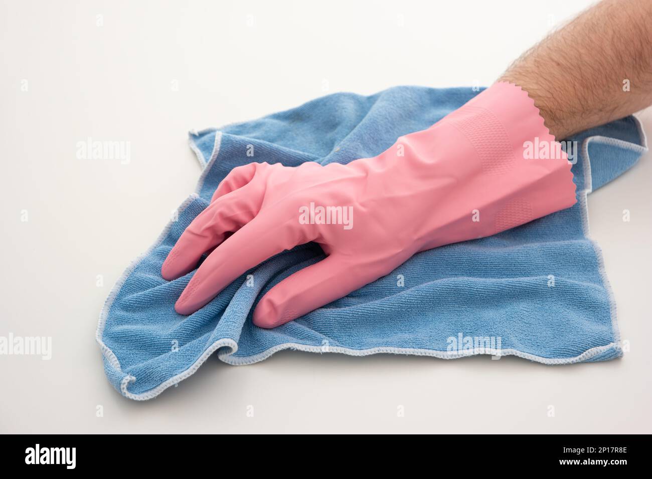 Pink latex cleaning glove on Caucasian male hand holding a blue ...