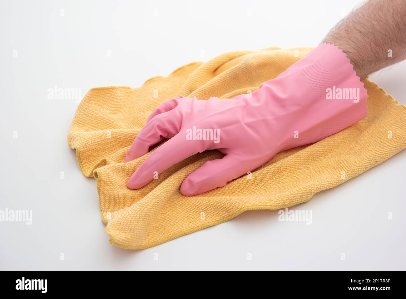 Pink latex cleaning glove on Caucasian male hand holding a yellow ...