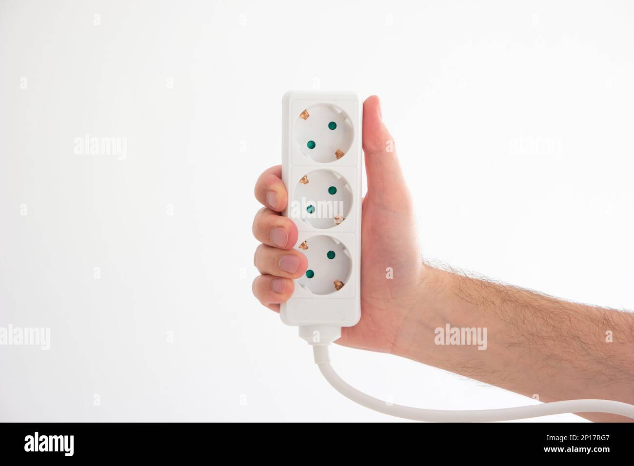 Electrical cord with multiple plug sockets held in hand by Caucasian ...