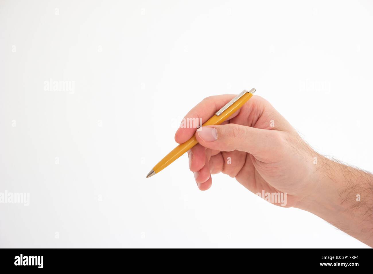 Yellow vintage plastic ball pen held in hand by Caucasian male hand ...