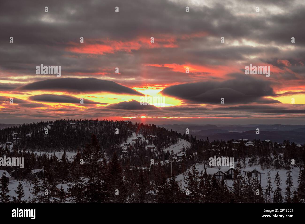 A landscape of hills covered in forests and snow during a beautiful ...