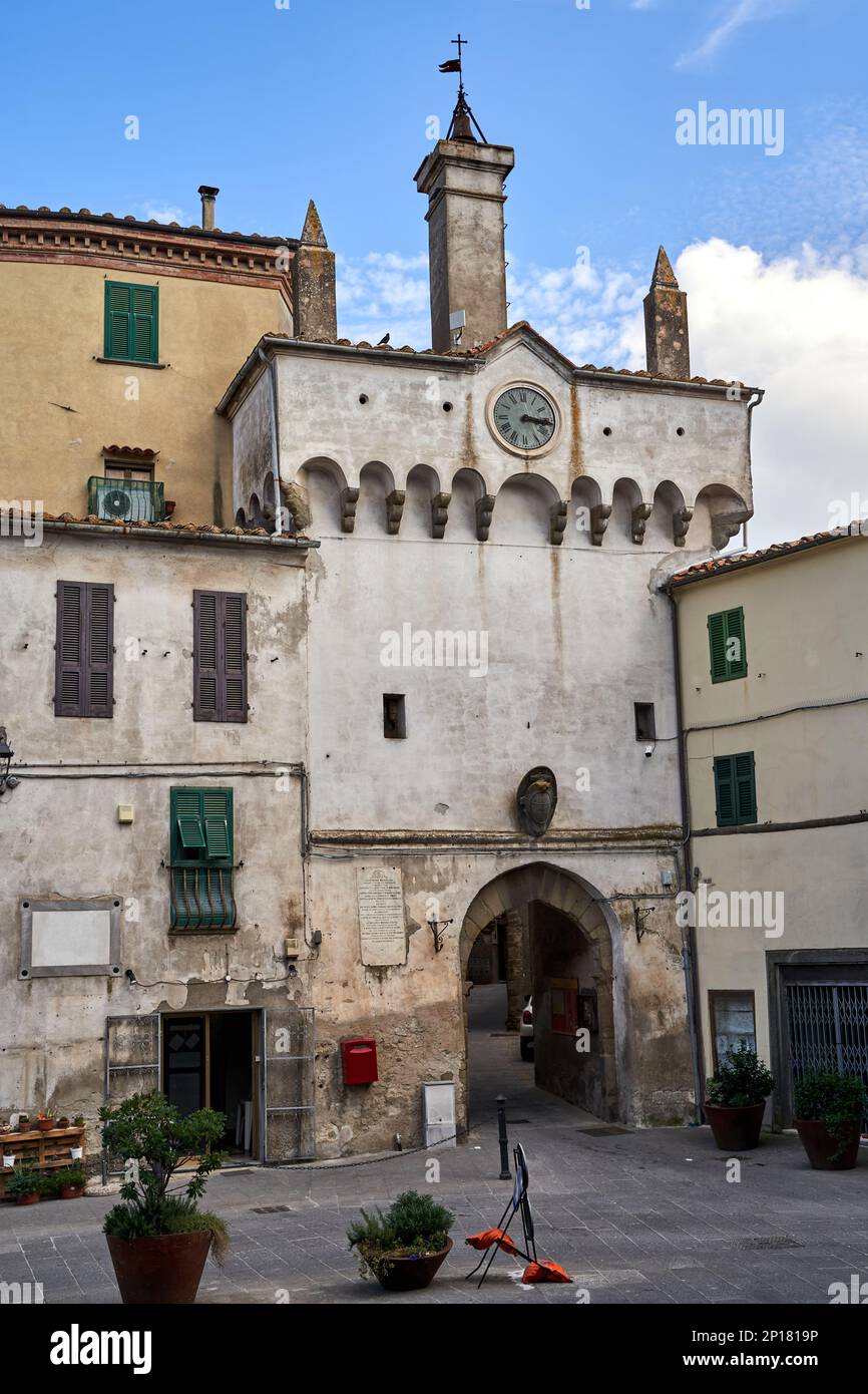 Cobblestone square with stone houses and city gate in Scansano, Italy ...