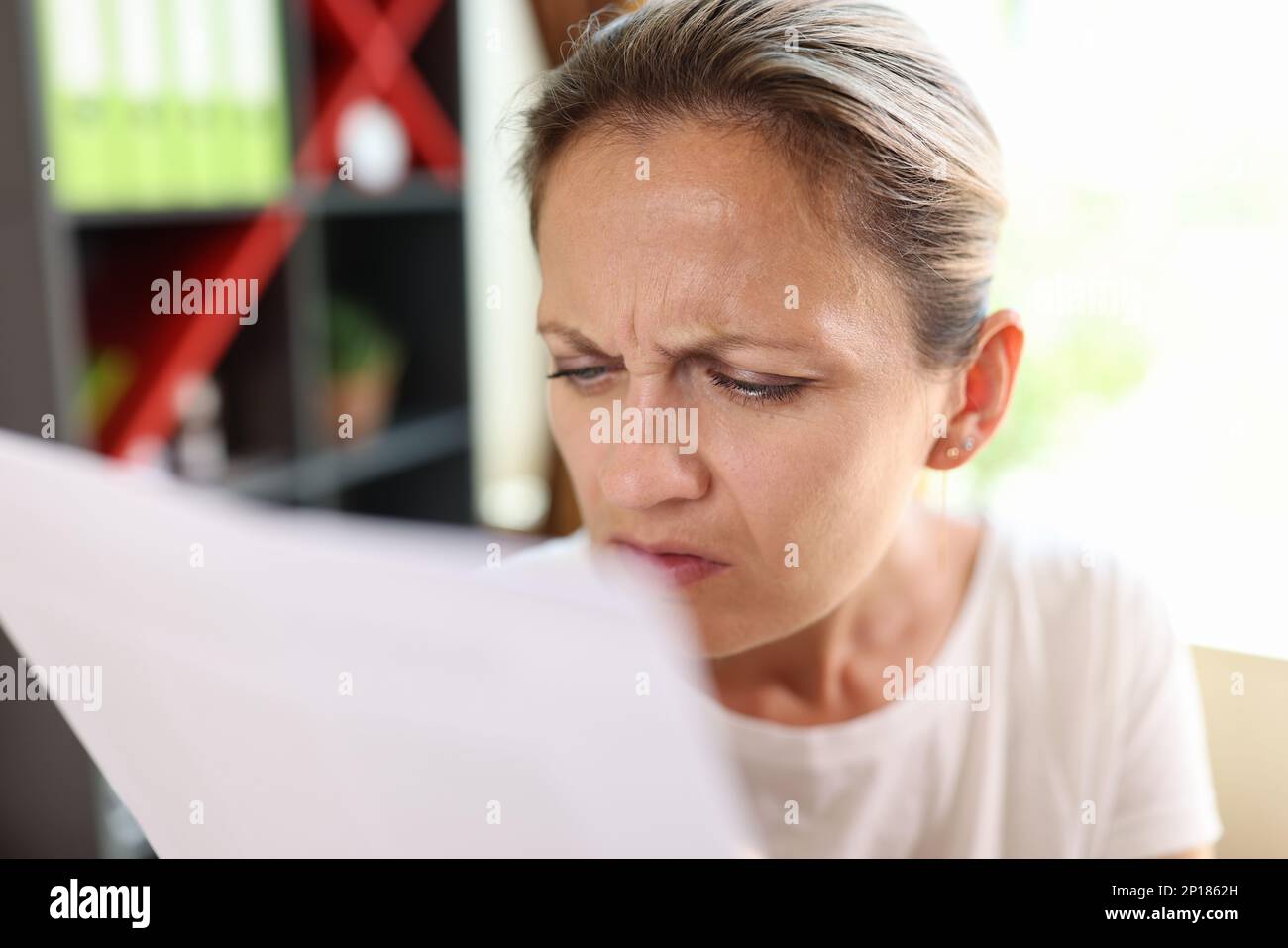 Focused woman trying read papers, squinting to see more clearly Stock ...