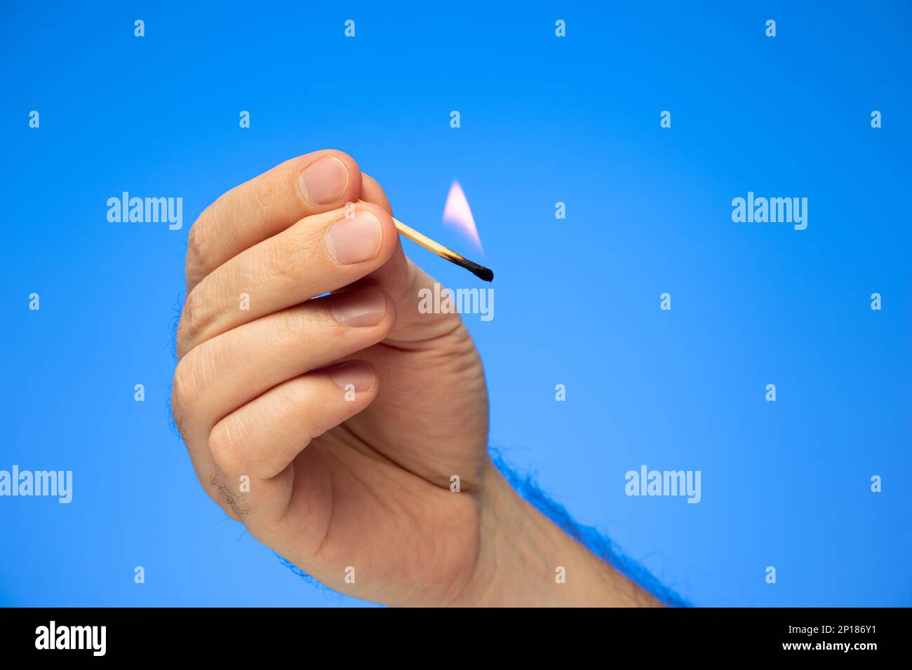 Lit matchstick held in hand by Caucasian male hand studio shot isolated ...