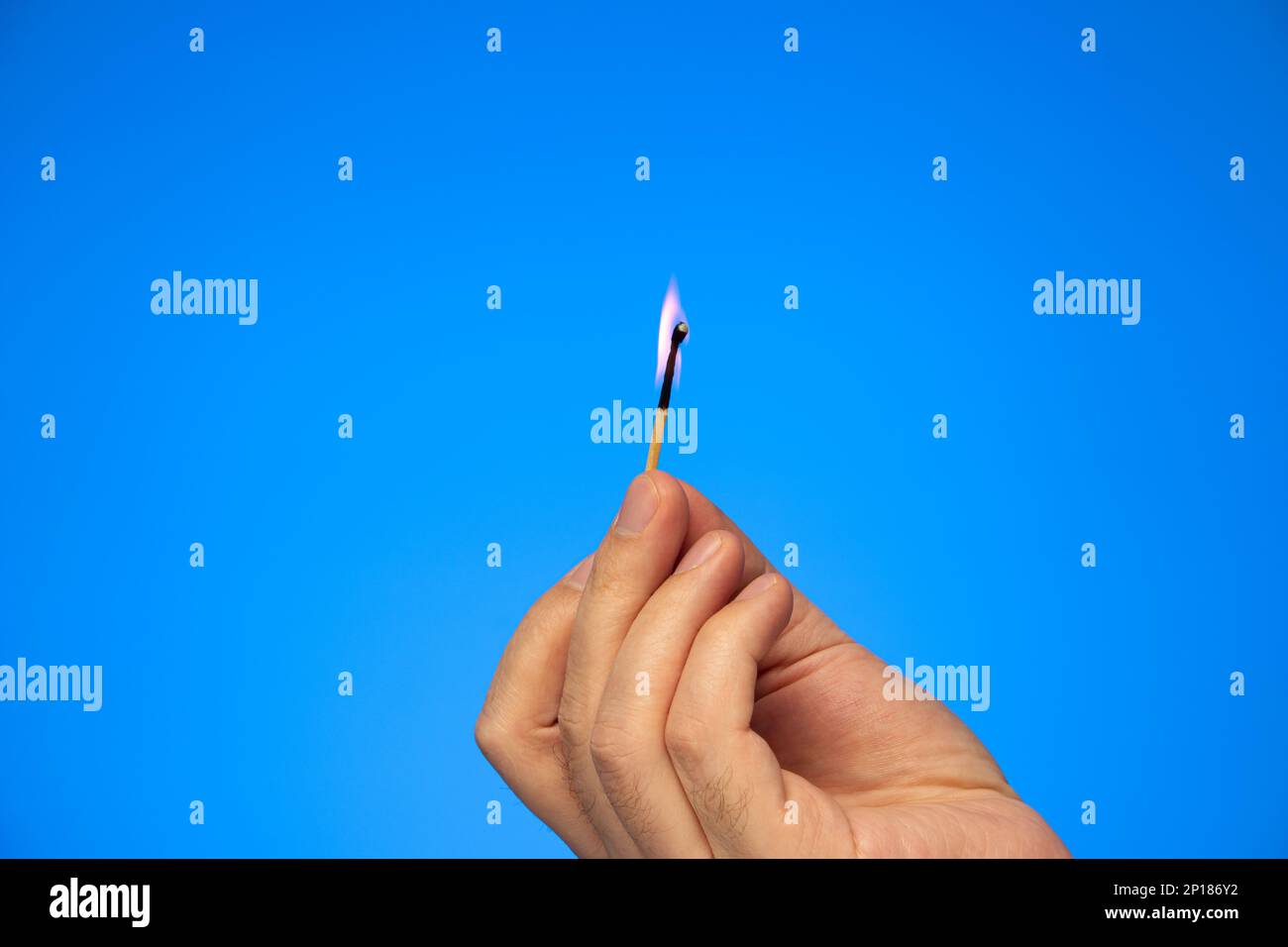 Lit matchstick held in hand by Caucasian male hand studio shot isolated ...