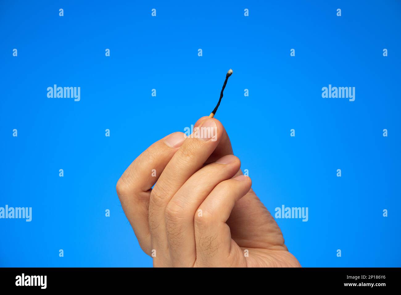 Charred matchstick held in hand by Caucasian male hand studio shot ...