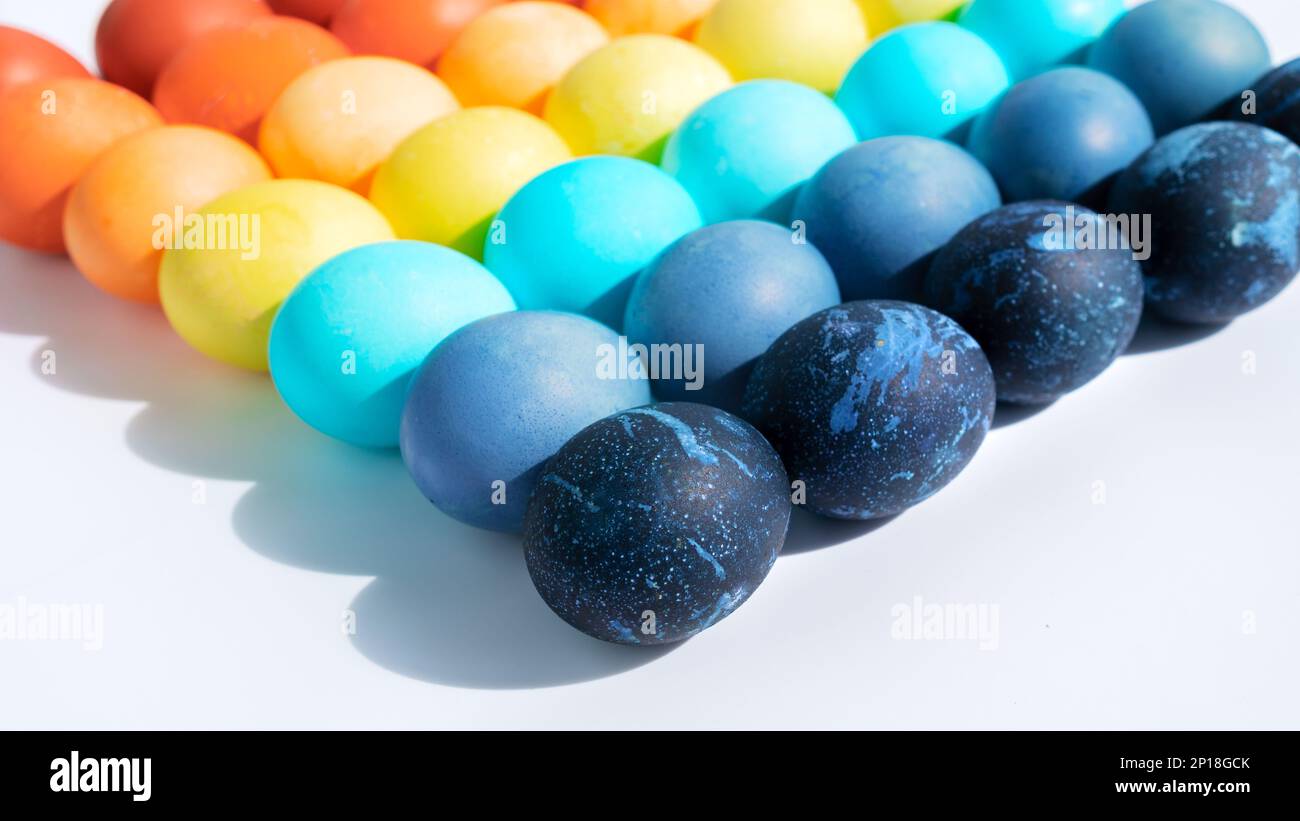 Easter eggs are painted in the colors of the rainbow and laid out in a ...