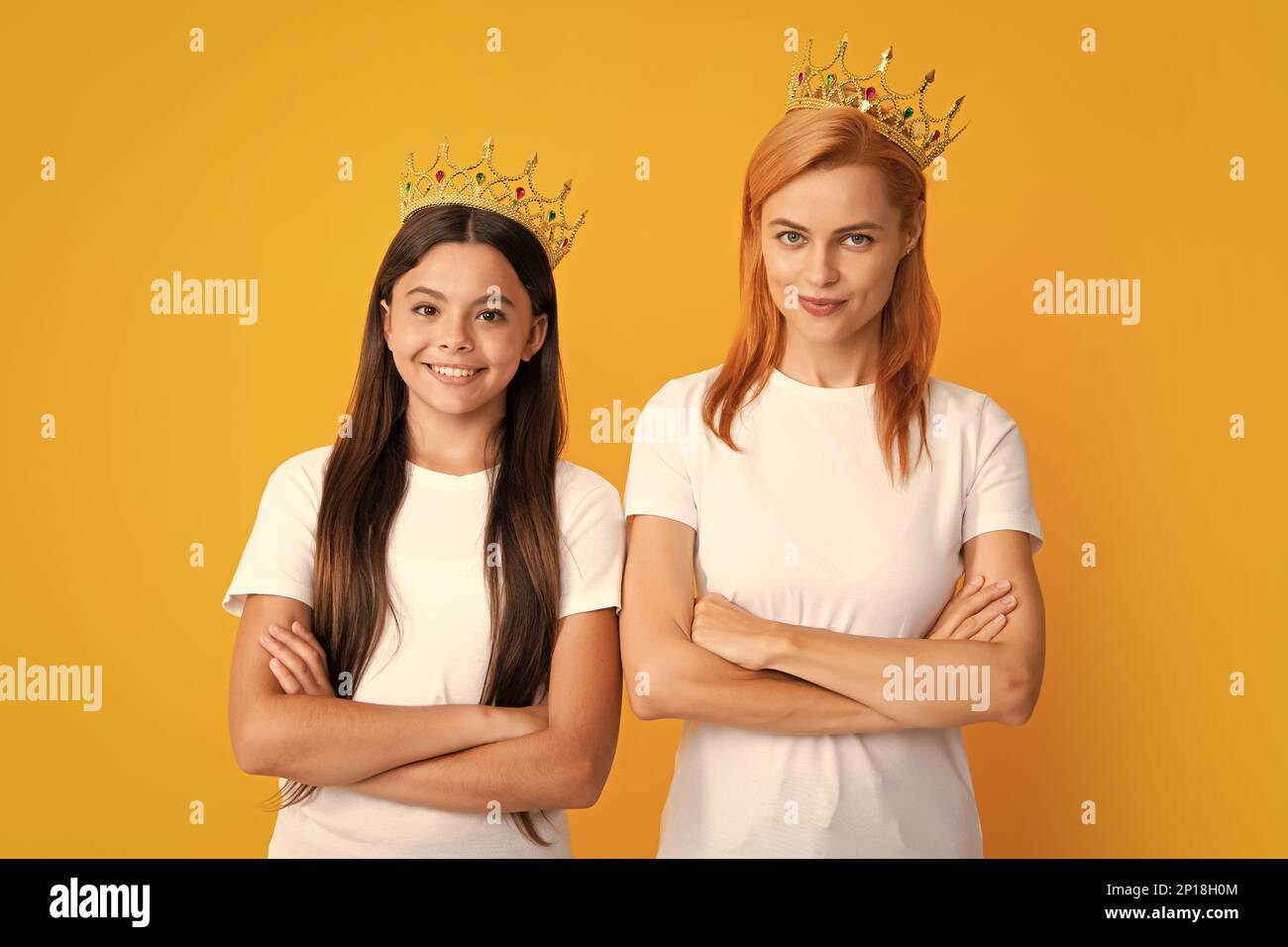 Arrogant mother and daughter child wearing crowns on yellow background ...