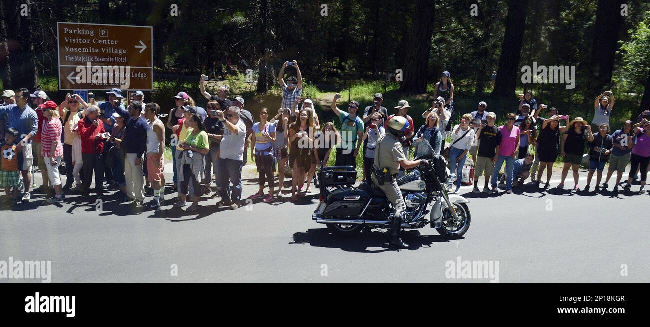 Park visitors wave and take photos as vehicles from President Barack ...