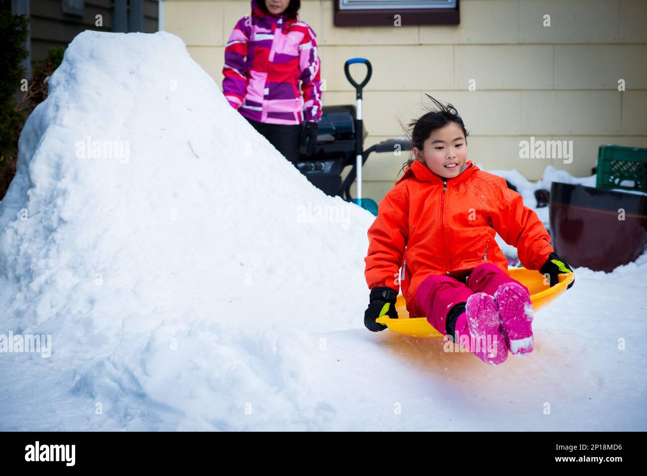 Young asian girl sledding after snow Stock Photo - Alamy