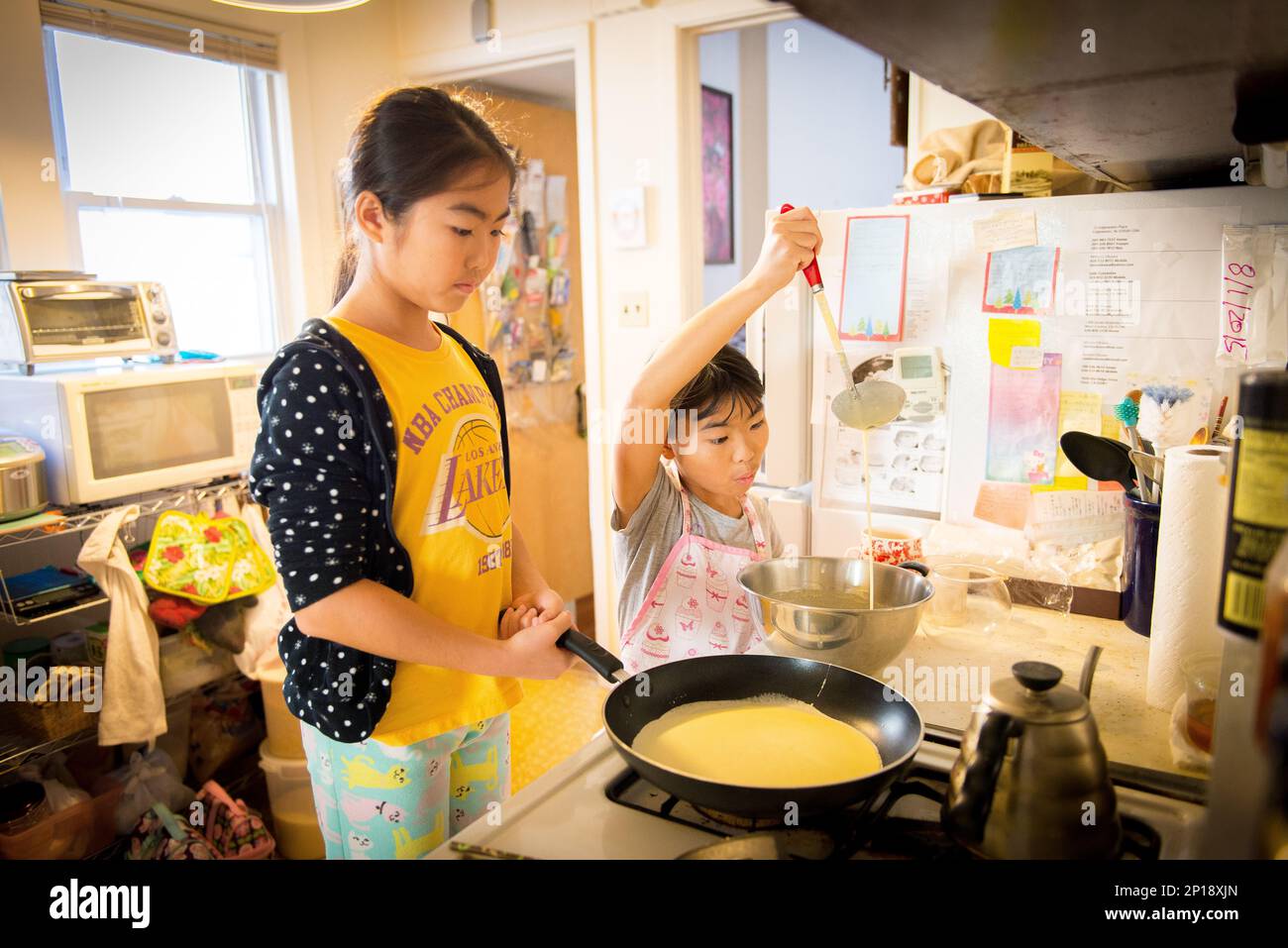 Two young asian girls making crepe for breakfast in the kitchen Stock ...