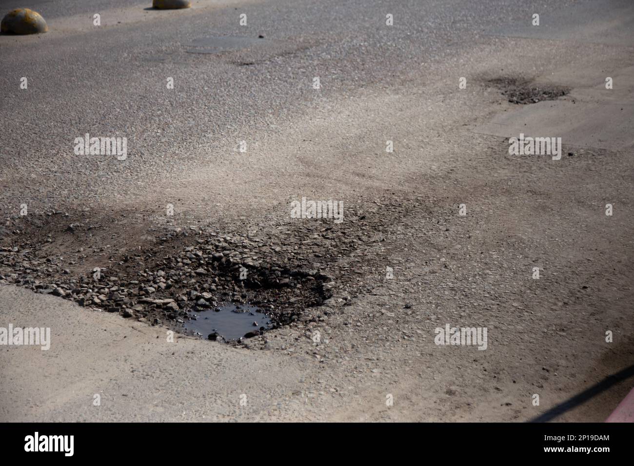 Damaged asphalt road with potholes caused by freezing and thawing ...