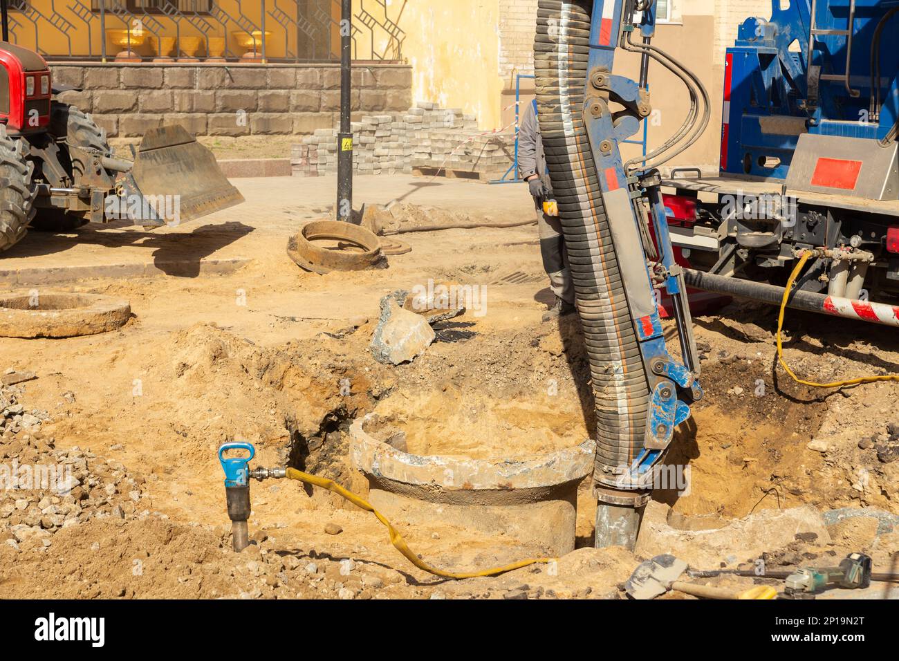 Workers use a suction excavator based on a truck to sample soil in a ...