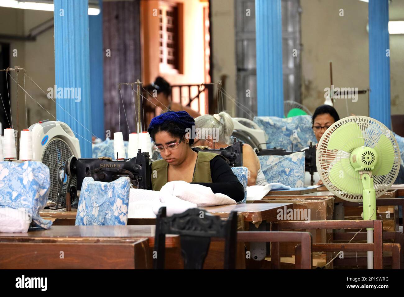 Cuban women working on old sewing machines. Seamstress sews textile in workshop Stock Photo - Alamy