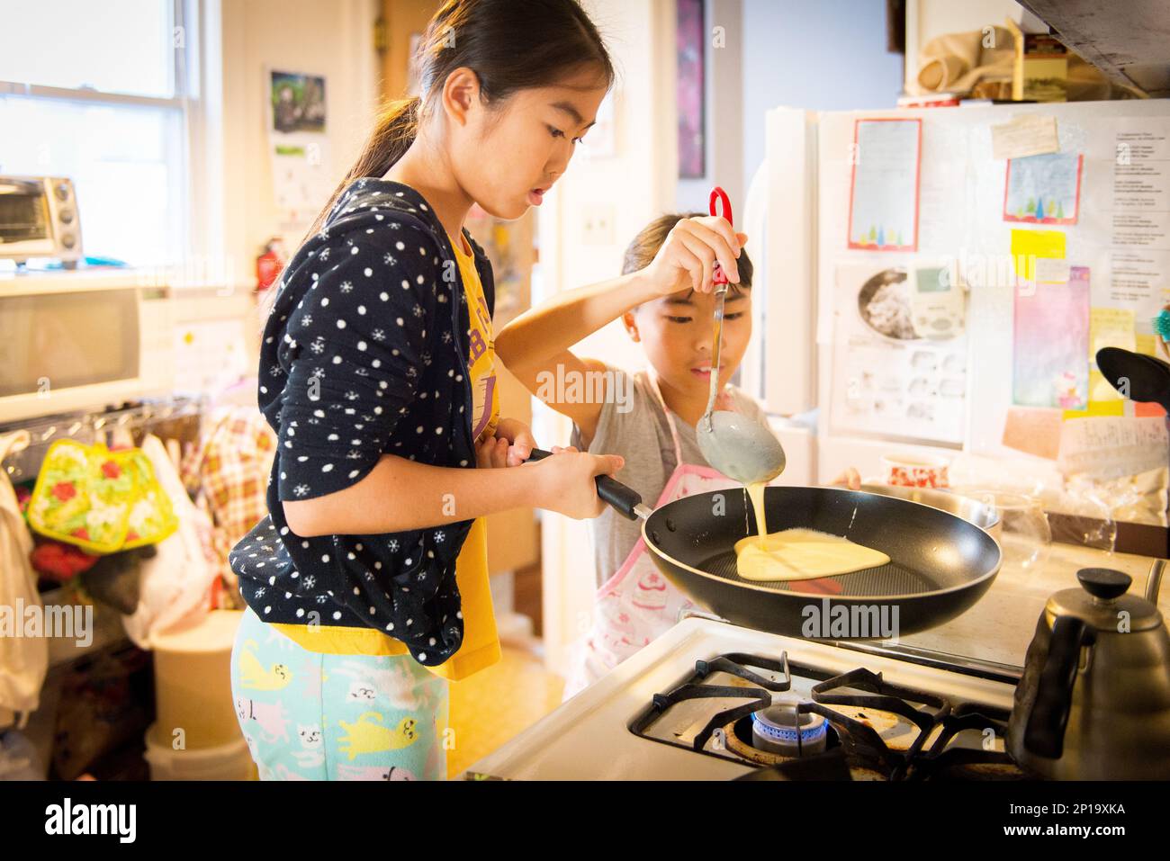 Two young asian girls making crepe for breakfast in the kitchen Stock ...