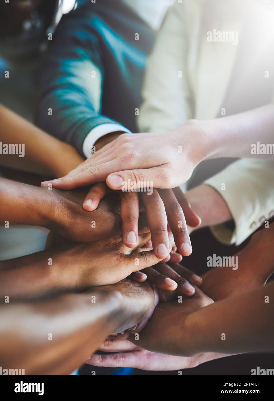 Unity is strength. Cropped shot of a group of businesspeople piling ...