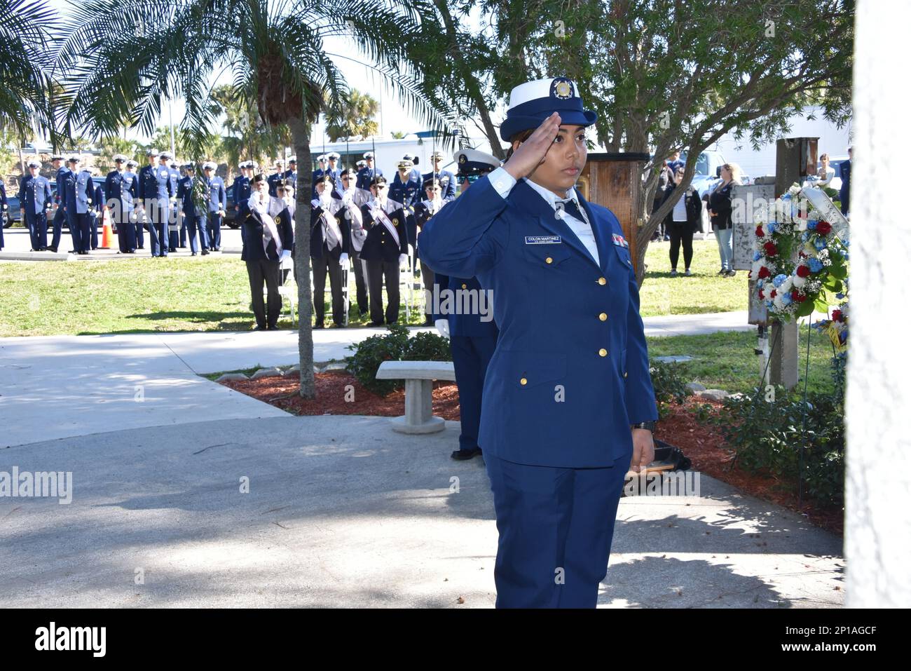 A Coast Guardsman salutes in front of the Coast Guard Cutter Blackthorn ...