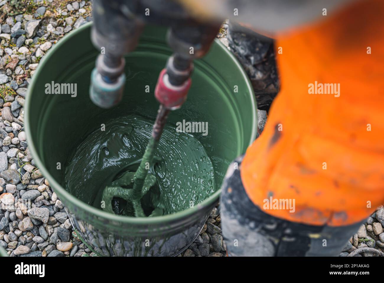 Skilled worker mixes epoxy resin paint. Epoxy flooring tools ...